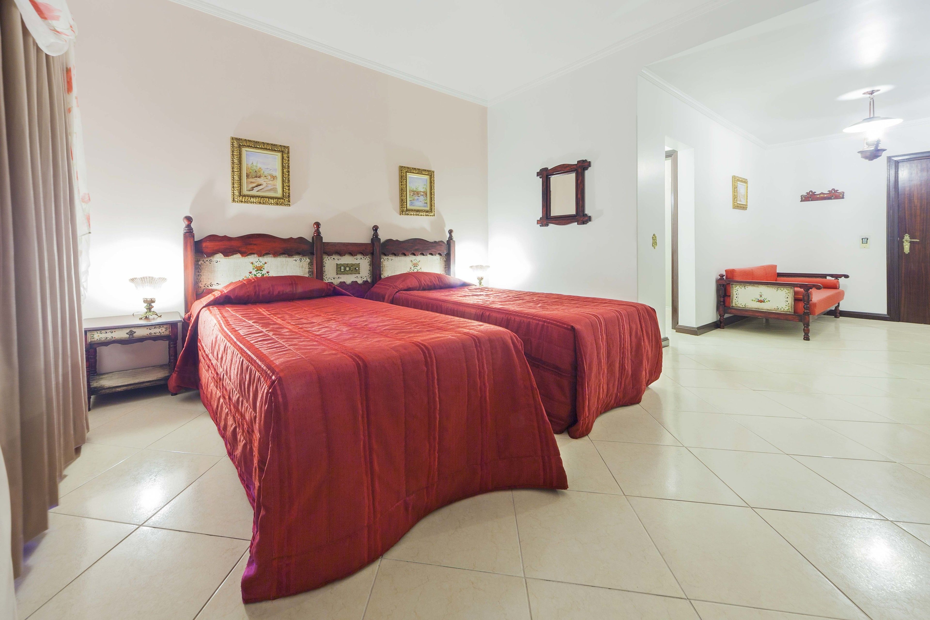 Quarto com duas camas, uma mesa de cabeceira, um penteado e uma porta.