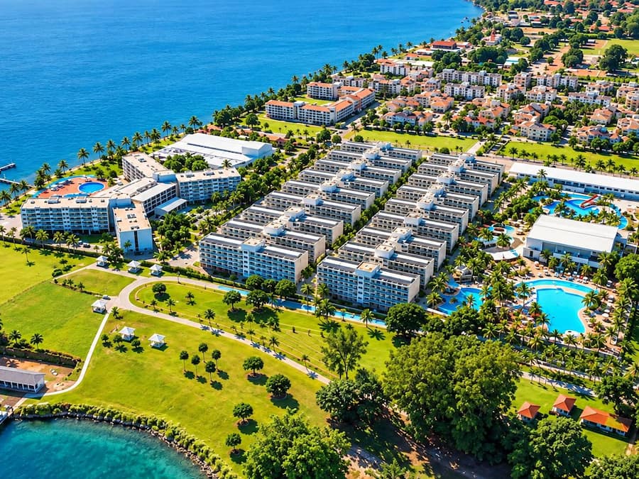 Vista aérea de um resort com vários edifícios, um cais e uma grande piscina.