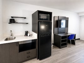 Uma cozinha moderna com micro-ondas, frigorífico e máquina de café integrados.