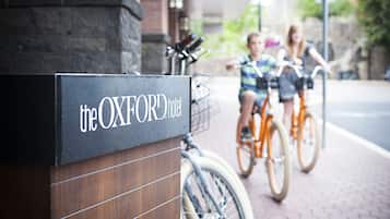 Placa do 'The Oxford Hotel', com fachada de madeira e suporte de metal para bicicletas.