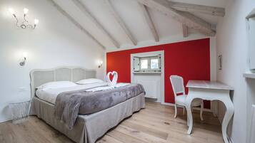 Quarto com cama, escrivaninha, cadeira e parede de destaque vermelha.