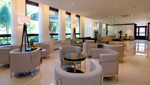 Um hall amplo com mobiliário moderno, janelas grandes e interior limpo e bem iluminado.