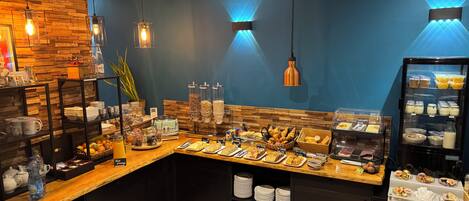 Um buffet de café da manhã com diversas opções de comida e um espaço para café.