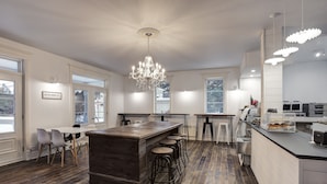 Uma cozinha moderna com ilha central, banquetas e um candelabro.