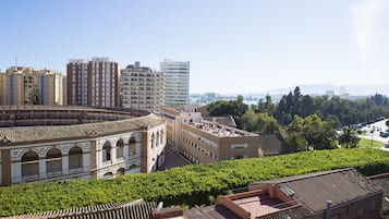 Um edifício histórico com um pátio central, rodeado por edifícios modernos e altos.