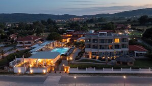 Um resort com piscina, vários edifícios e uma área externa bem iluminada.