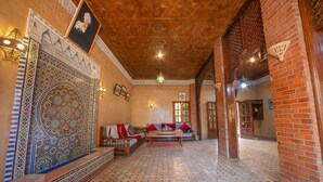 Um interior tradicional com parede estampada, um sofá e teto de madeira.