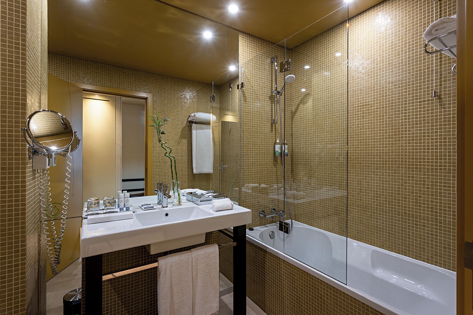 Uma casa de banho moderna com uma banheira grande, um chuveiro com parede de vidro e um lavatório com espelho e lavatório.