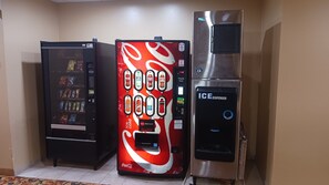 Máquina de vendas com o logotipo da Coca-Cola, máquina de bebidas e dispensador de gelo.