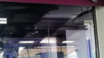 Um café chamado 'SILVER', com entrada de vidro e área de estar visível no interior.
