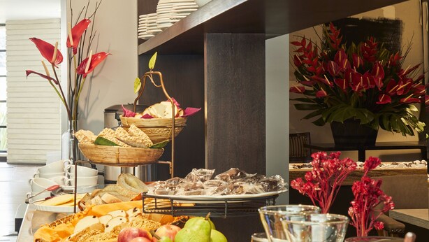 Uma mesa de buffet com diversos alimentos e bebidas.