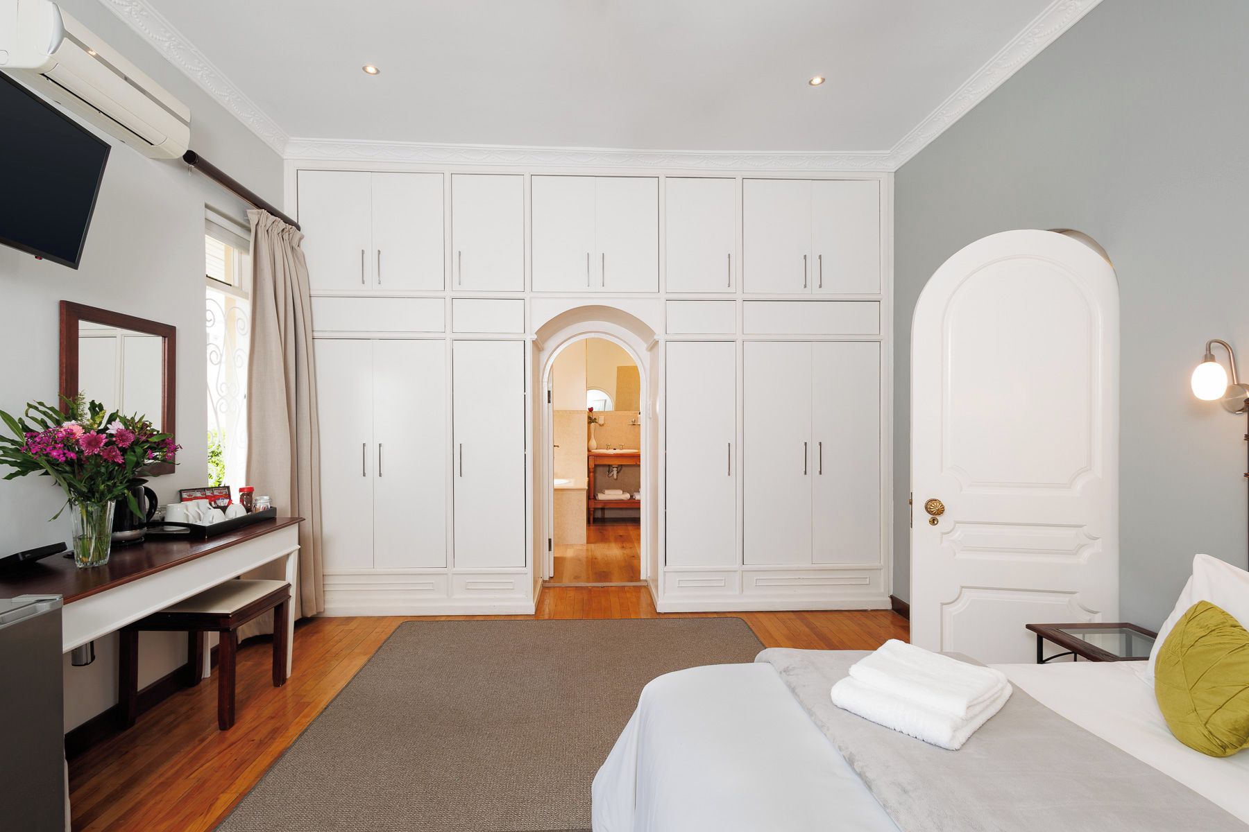Quarto com cama, escrivaninha e guarda-roupa.