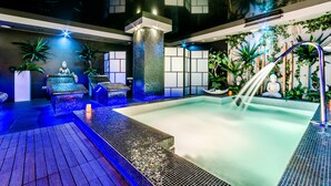 Uma área de spa com hidromassagem, assentos e plantas decorativas.
