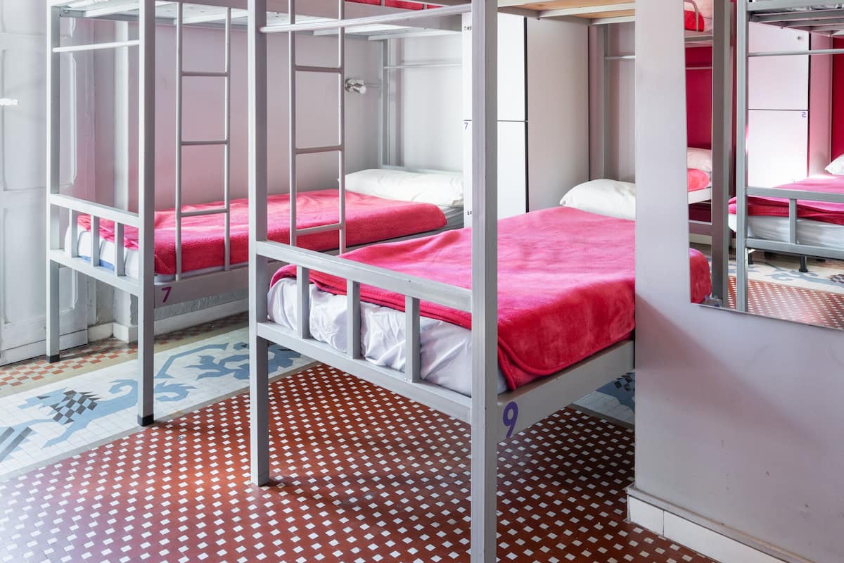 Quarto com beliche, piso estampado e uma porta.