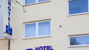 Um hotel chamado "Hotel Europa", com uma área de recepção e uma exposição de fotografias emolduradas na entrada.