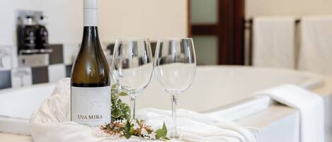 Uma garrafa de vinho Uvamira, dois copos e um pano branco sobre uma mesa.