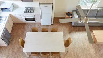Uma cozinha moderna com área de refeições, um sofá e um ventilador de teto.