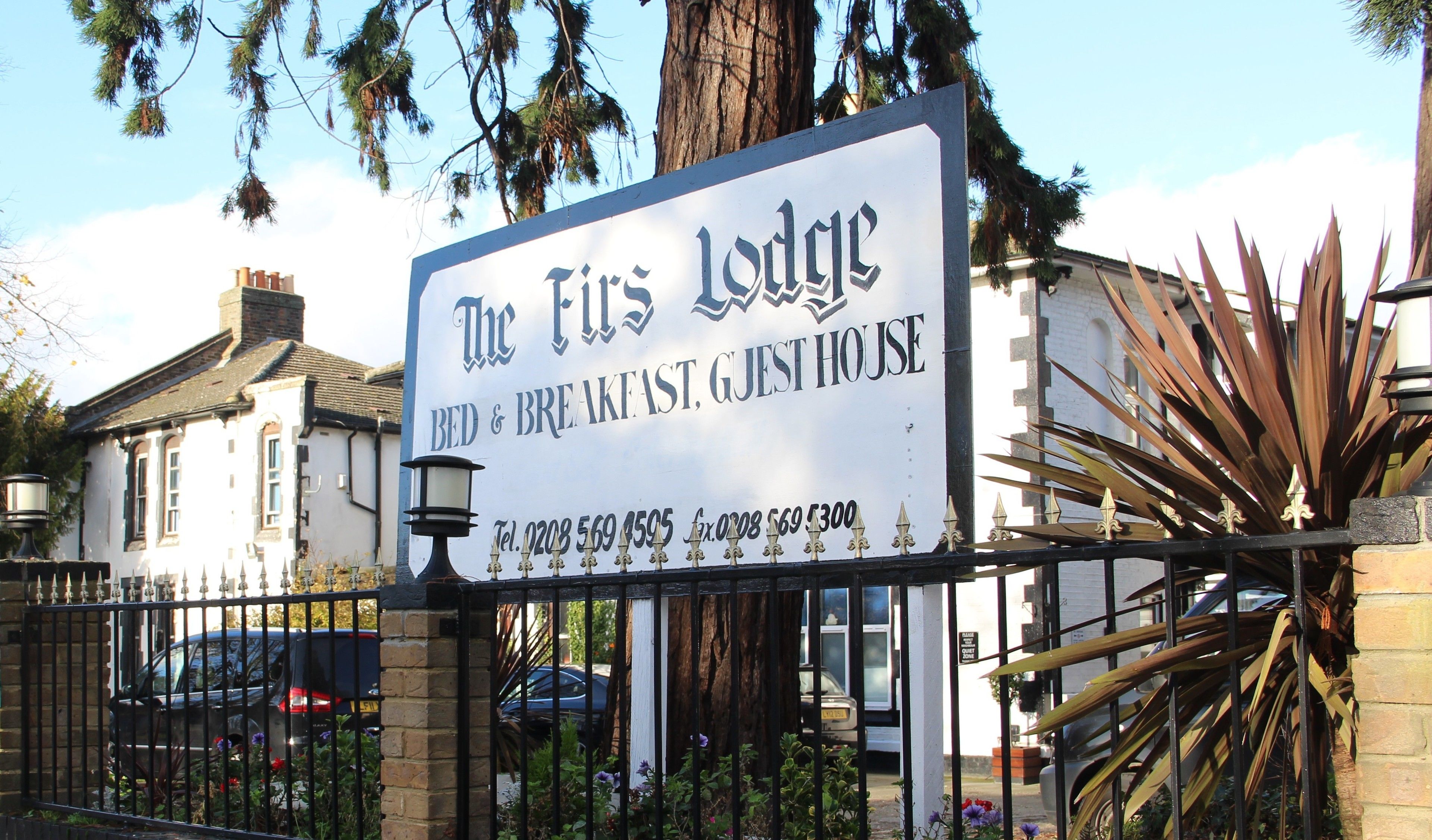 Placa indicando The First Lodge, com serviços de hospedagem e café da manhã.
