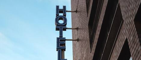 Placa de hotel com uma grande inscrição 'HOTEL' e um logotipo acima.