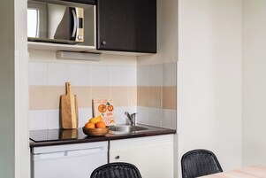 Um frigorífico, um micro-ondas, uma placa de cozinha 