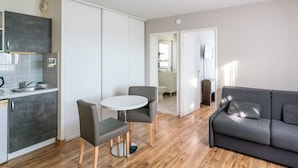Um espaço de estar moderno com cozinha, sala de jantar e um sofá.