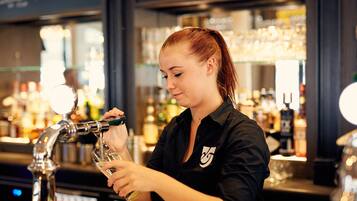 Um bartender servindo uma bebida de uma torneira.