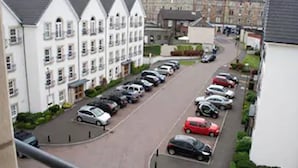 Rua residencial com carros estacionados e casas.