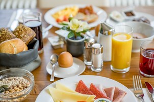 Uma mesa de café da manhã com diversos alimentos, incluindo pão, ovos e frutas.