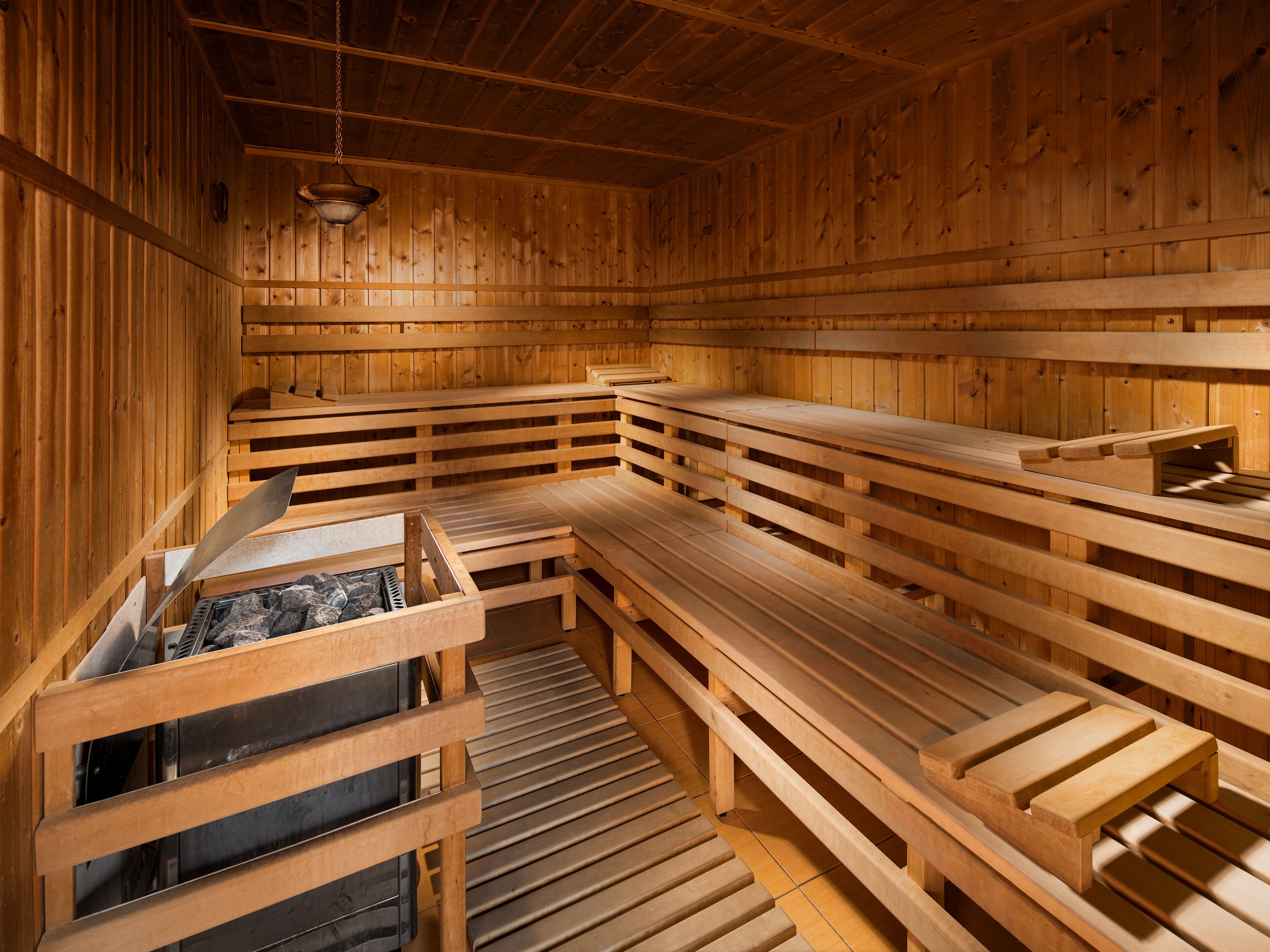 Uma sauna de madeira com bancos e um aquecedor de pedra.