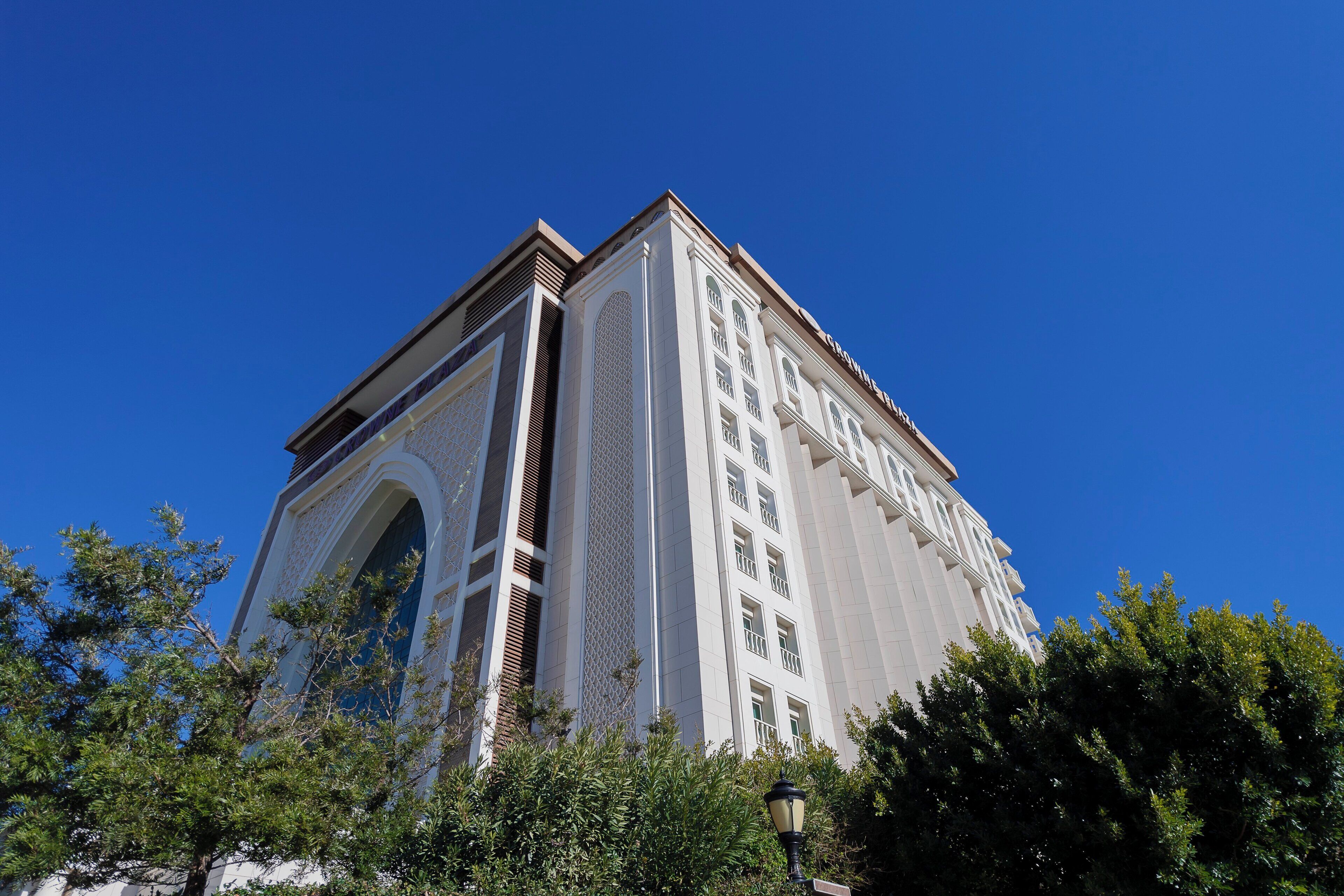 Um edifício grande e branco com uma entrada em arco destacada e várias janelas.