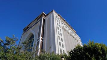 Um edifício grande e branco com uma entrada em arco destacada e várias janelas.