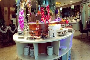 Disposição de buffet com diversos alimentos e elementos decorativos.