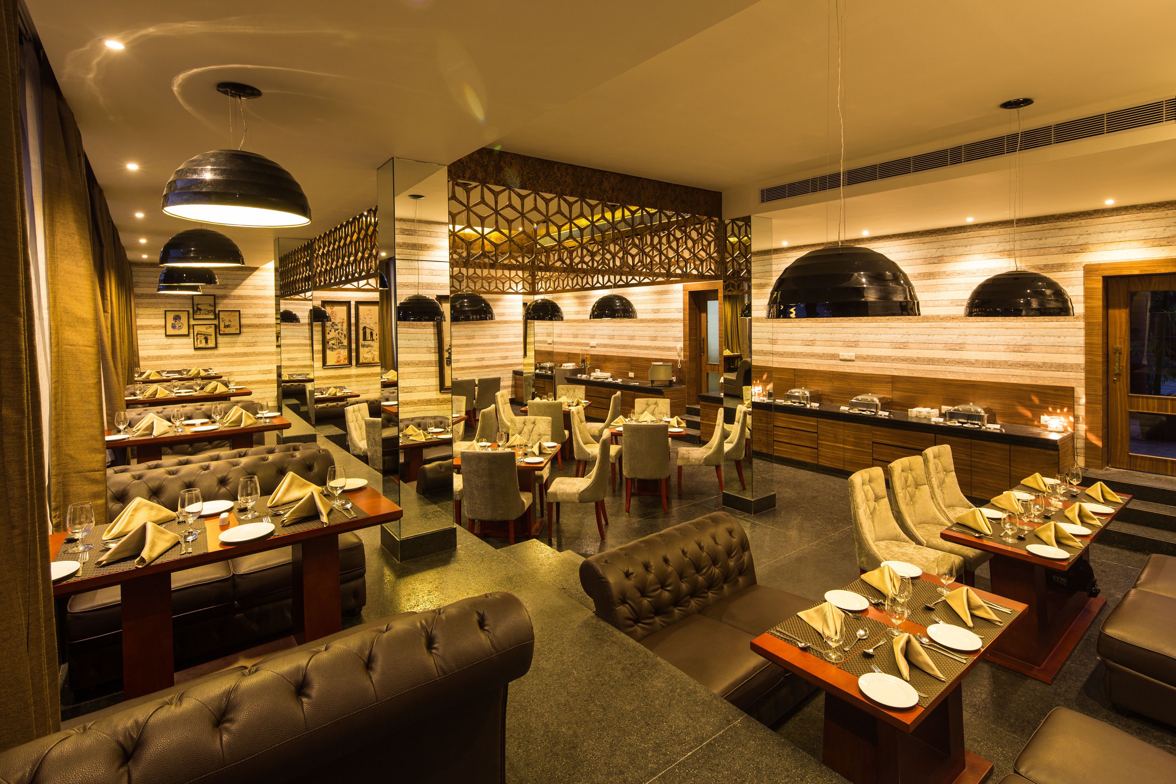 Restaurante moderno com assentos de couro, mesas de madeira e uma parede decorativa.