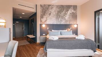 Quarto moderno com uma cama grande, um banquinho e um aplique de parede.