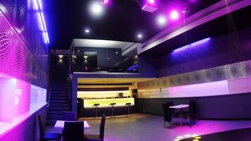 Um interior moderno com área de bar, assentos e escada.