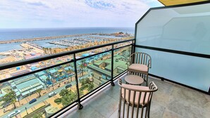 Uma varanda com vista para uma marina e uma praia.