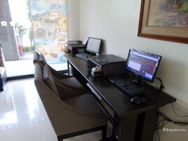Um escritório em casa com uma mesa, dois computadores, um teclado e um rato.