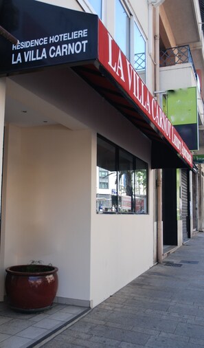 Fachada de hotel com placa indicando "RESIDENCE HOTELIERE LA VILLA CARNOT".