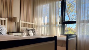 Quarto triplo superior, várias camas | Edredons de pluma, frigobar, escrivaninha