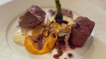 Um prato com carne, legumes e molho.