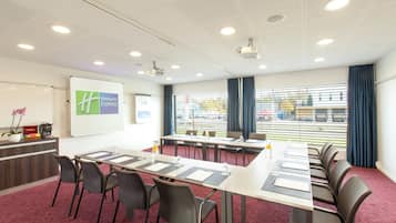Uma sala de conferências com quadro branco, projetor e um letreiro do Holiday Inn Express.