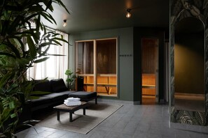 Uma sala de estar moderna com um sofá, uma mesa de centro e uma janela grande com cortinas.