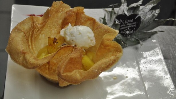 Sobremesa em tigela de waffle, com uma colherada de chantilly e a etiqueta com a inscrição 