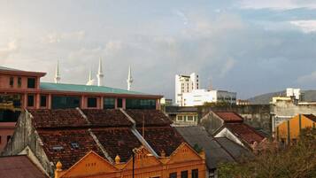 Vista de um horizonte urbano com edifícios históricos, incluindo um prédio em destaque com telhado verde e várias torres.