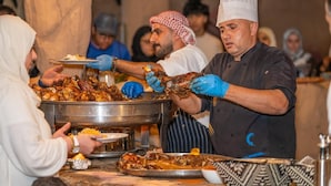 Buffet com carnes assadas e um chef servindo.