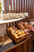 Vitrine de padaria com diversos pães e doces.