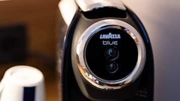 Uma cafeteira com a marca 'Lavazza Blue' sobre uma superfície de madeira.