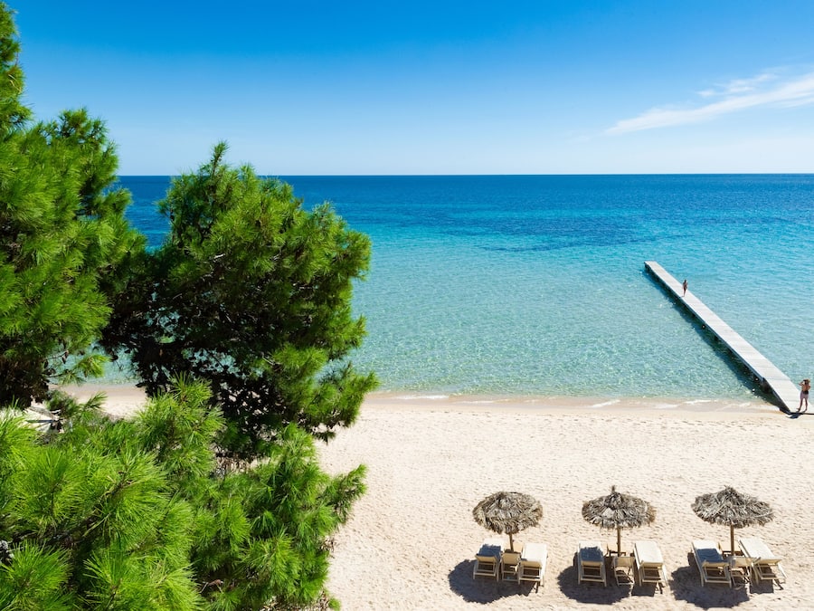 Uma praia privada, espreguiçadeiras, guarda-sóis de praia