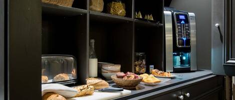 Uma bancada de cozinha com diversos alimentos e uma máquina de café.