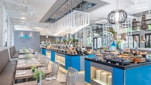 Um restaurante moderno com um balcão comprido, detalhes em azul e uma escada ao fundo.